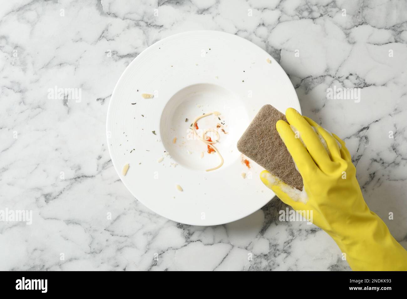 Woman washing dirty plate at white marble table, top view Stock Photo ...