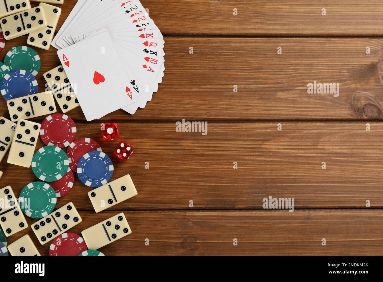 Elements of different board games on wooden table, flat lay. Space for ...