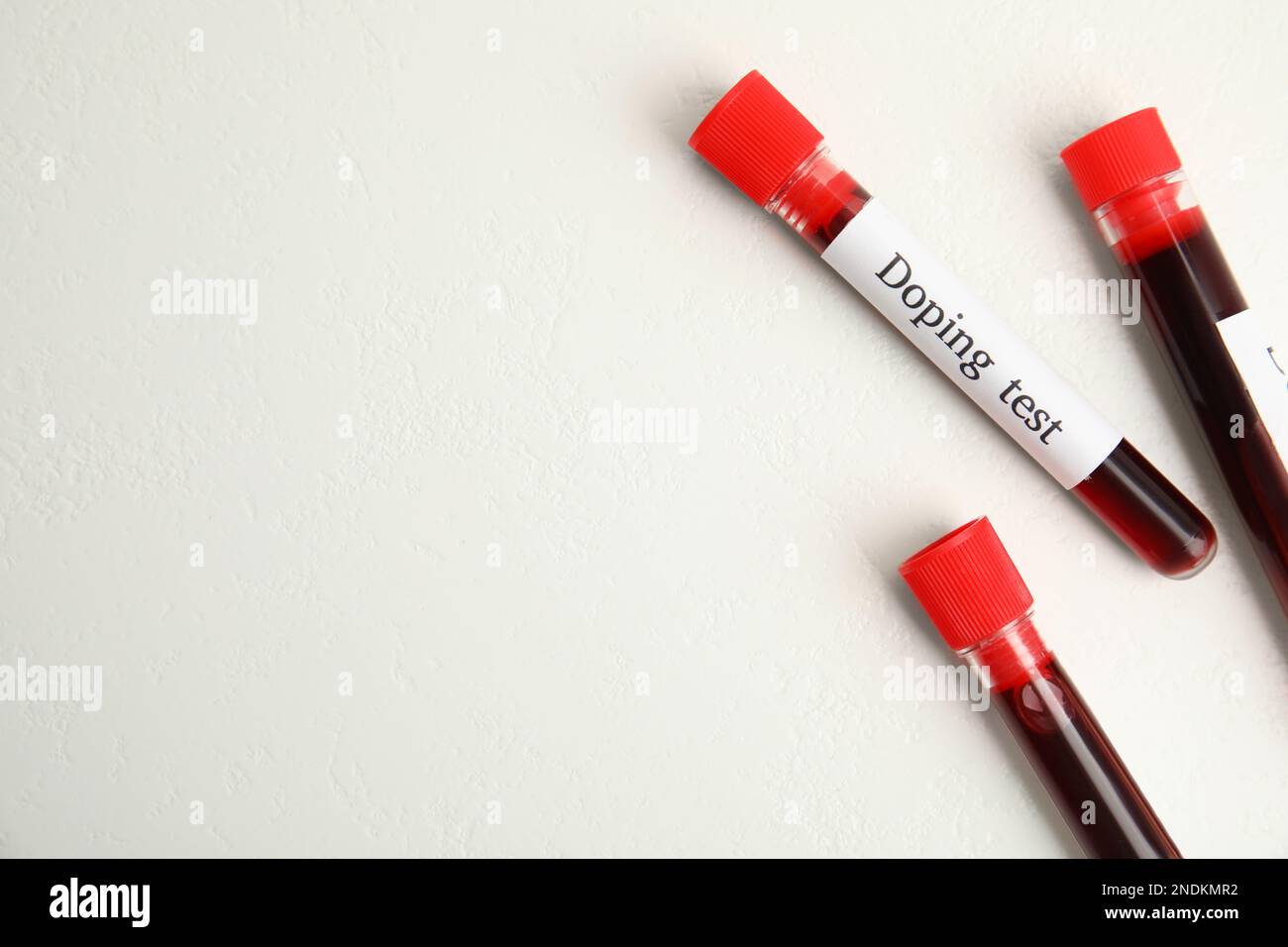 Test tubes with blood samples and space for text on beige background ...