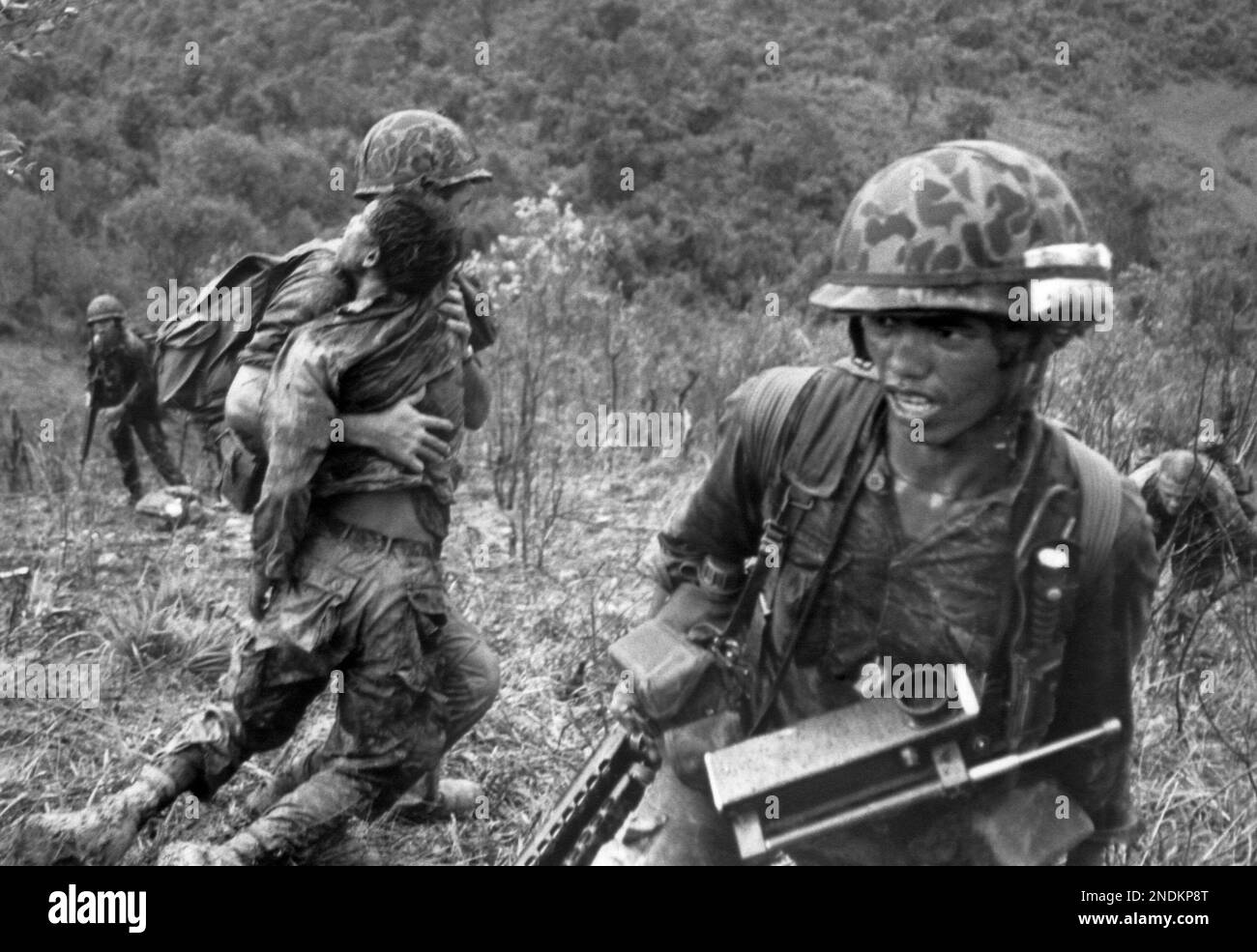 A medic drags a wounded South Vietnamese soldier to the bottom of the ...