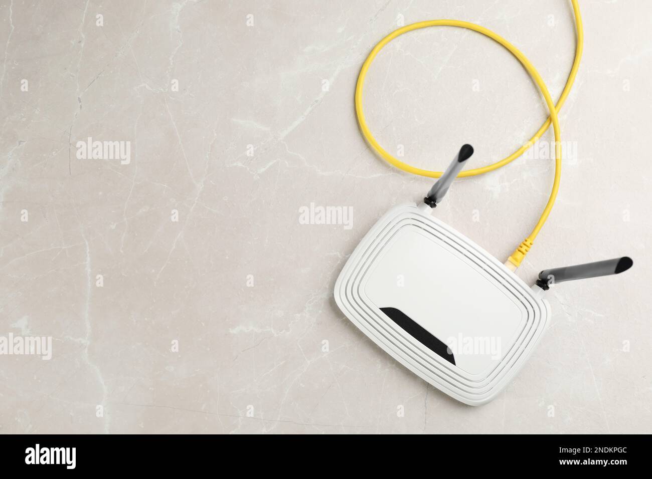 Modern Wi-Fi router on light grey marble background, top view. Space ...