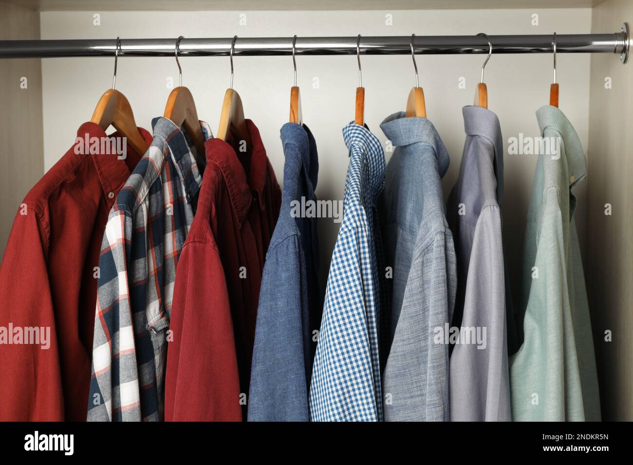 Hangers with clothes on rack in wardrobe Stock Photo - Alamy