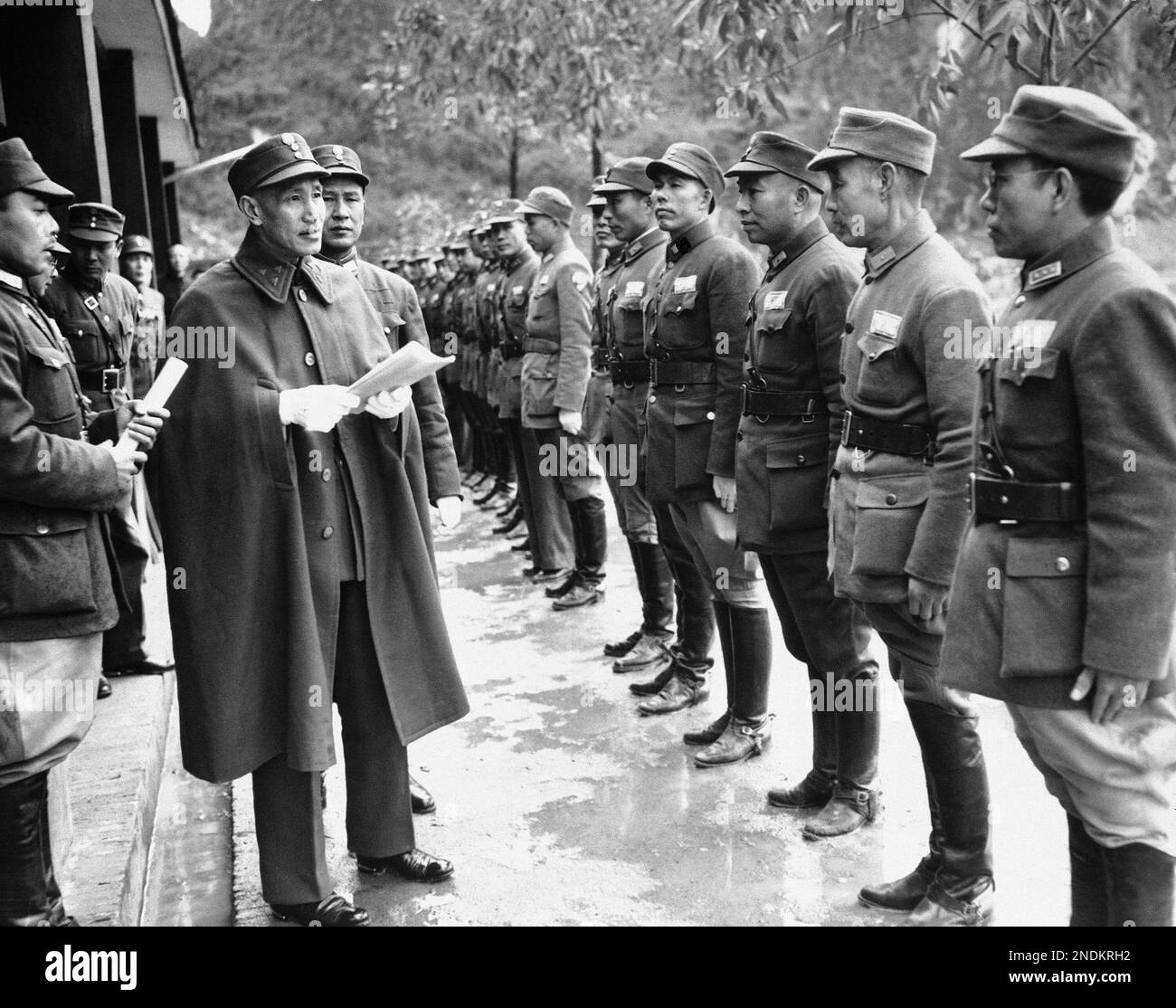 Generalissimo Chiang Kai-Shek, left in cape, talks to some of his ...