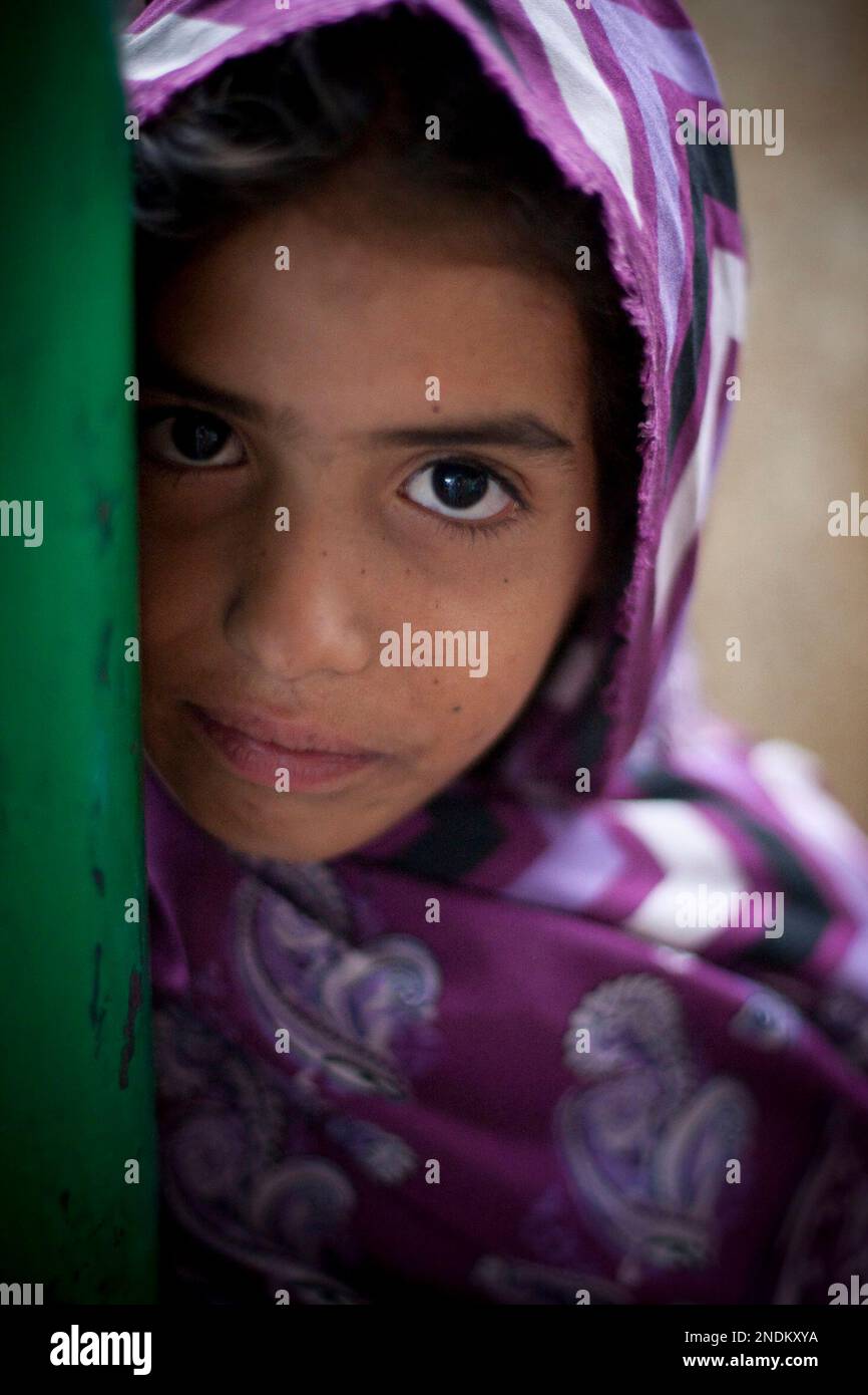 A Pakistani child as she waits to receive a ration of donated rice at ...