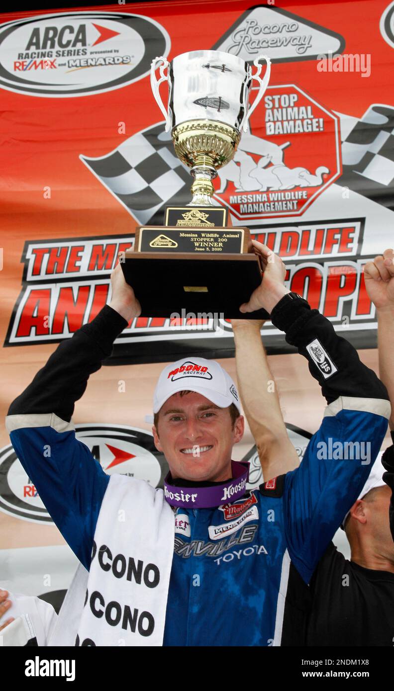 Driver Craig Goess poses with the trophy in victory lane after winning ...