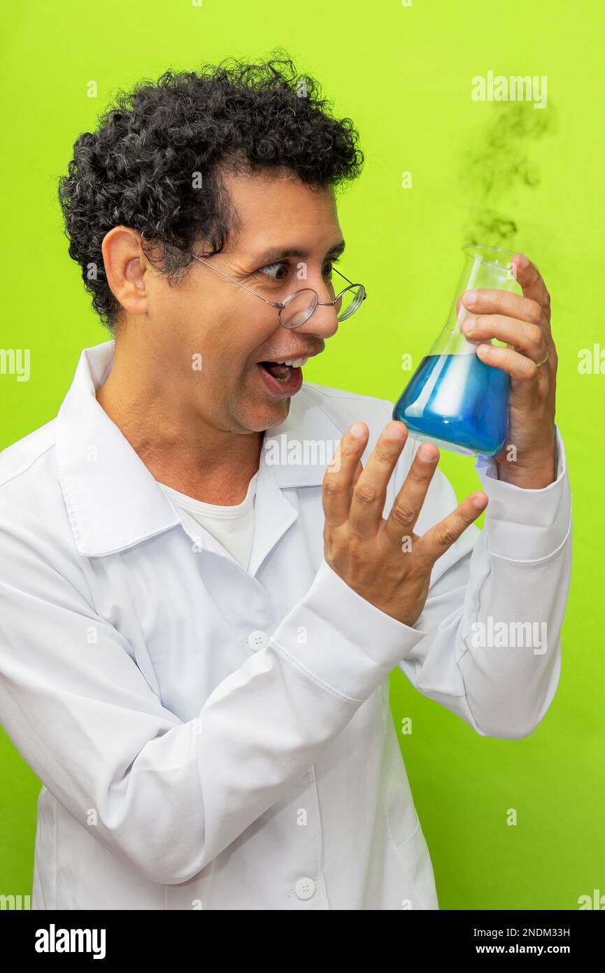 Happy genius scientist with his experiment portrait on green background ...