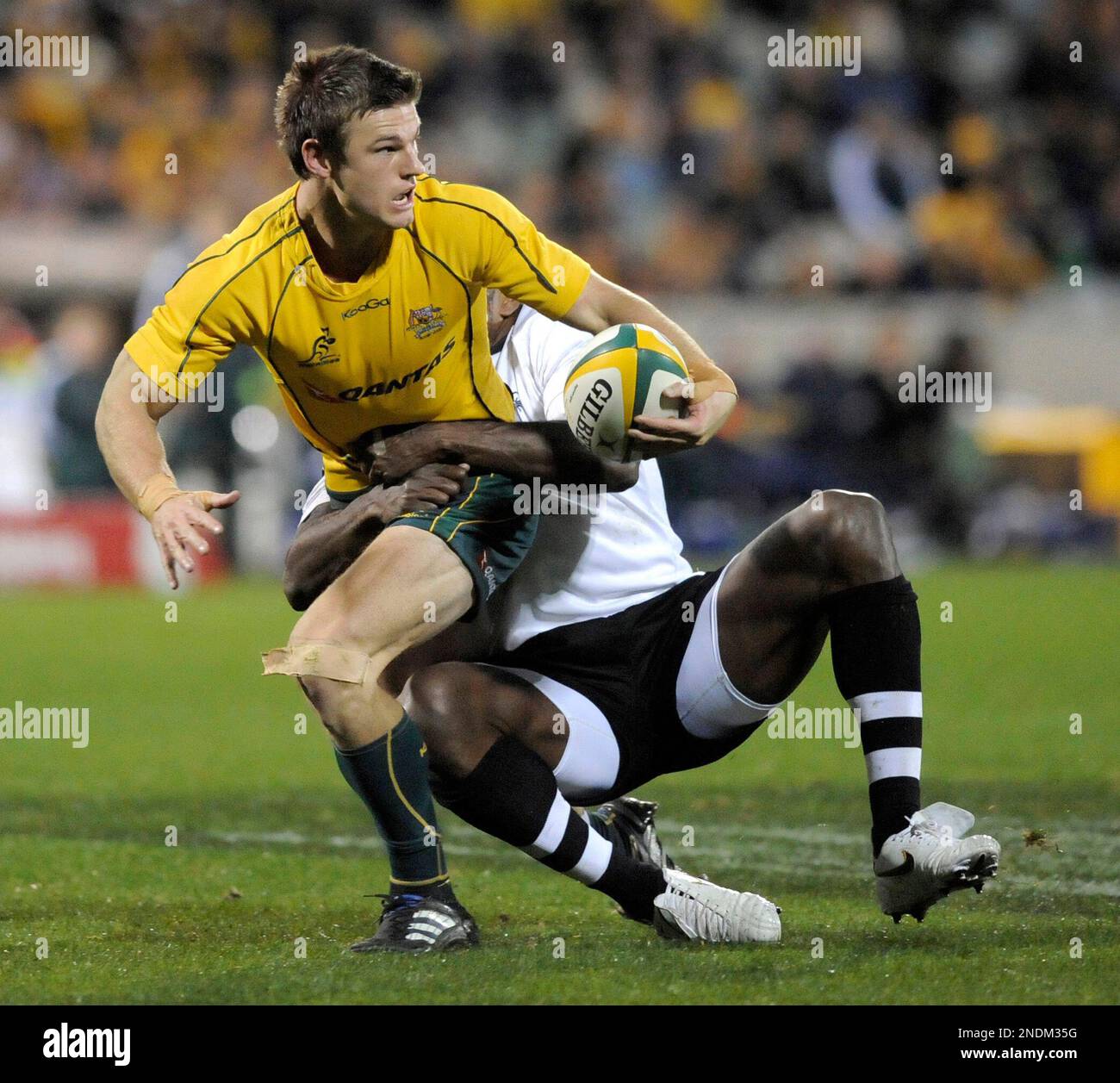 Australian Wallabies player Rob Horne tries to fend off a tackle by a ...