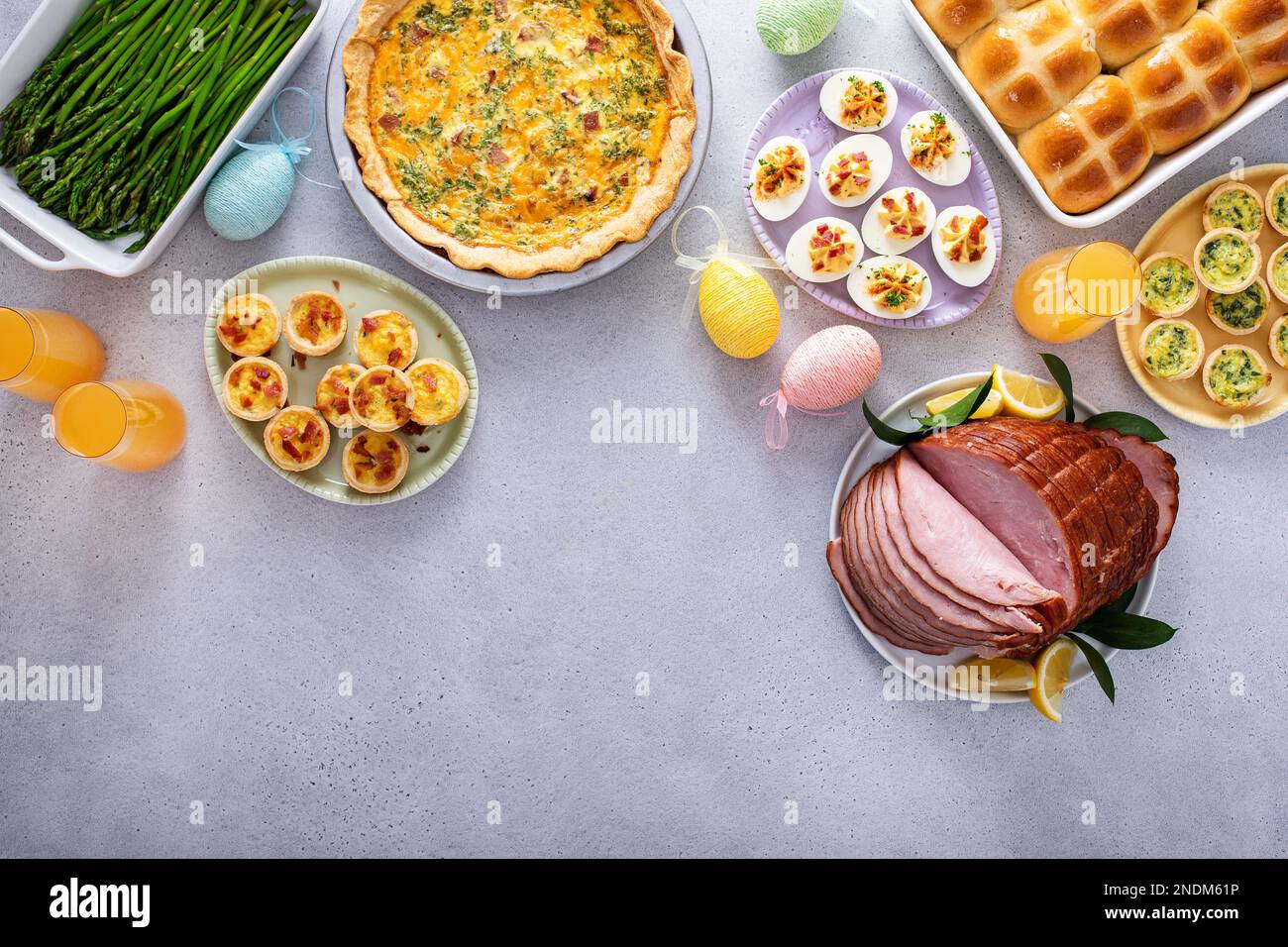 Easter brunch table with ham, quiche, hot cross buns and deviled eggs ...
