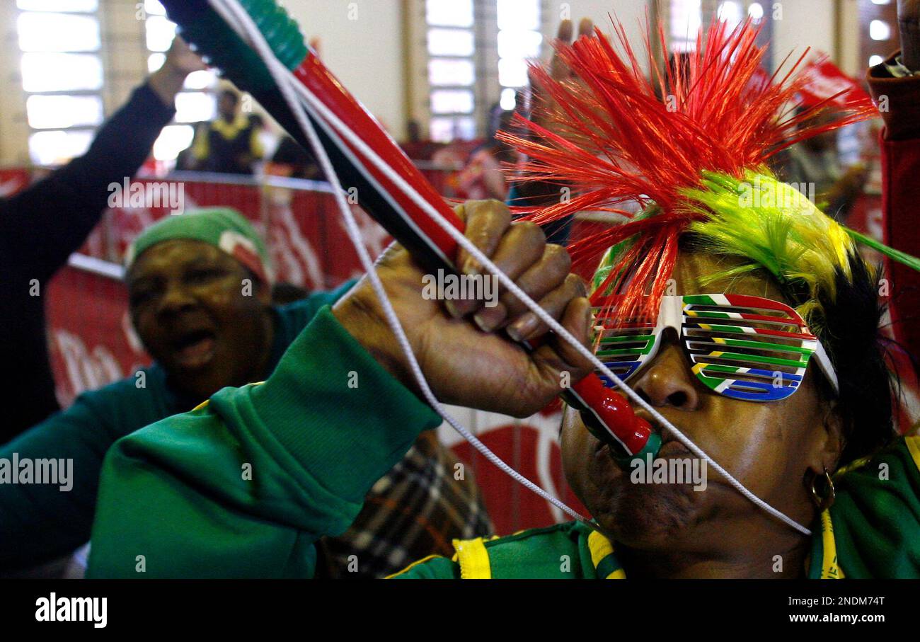 South African blows a vuvuzuela (plastic trumpet) as they queue to see ...