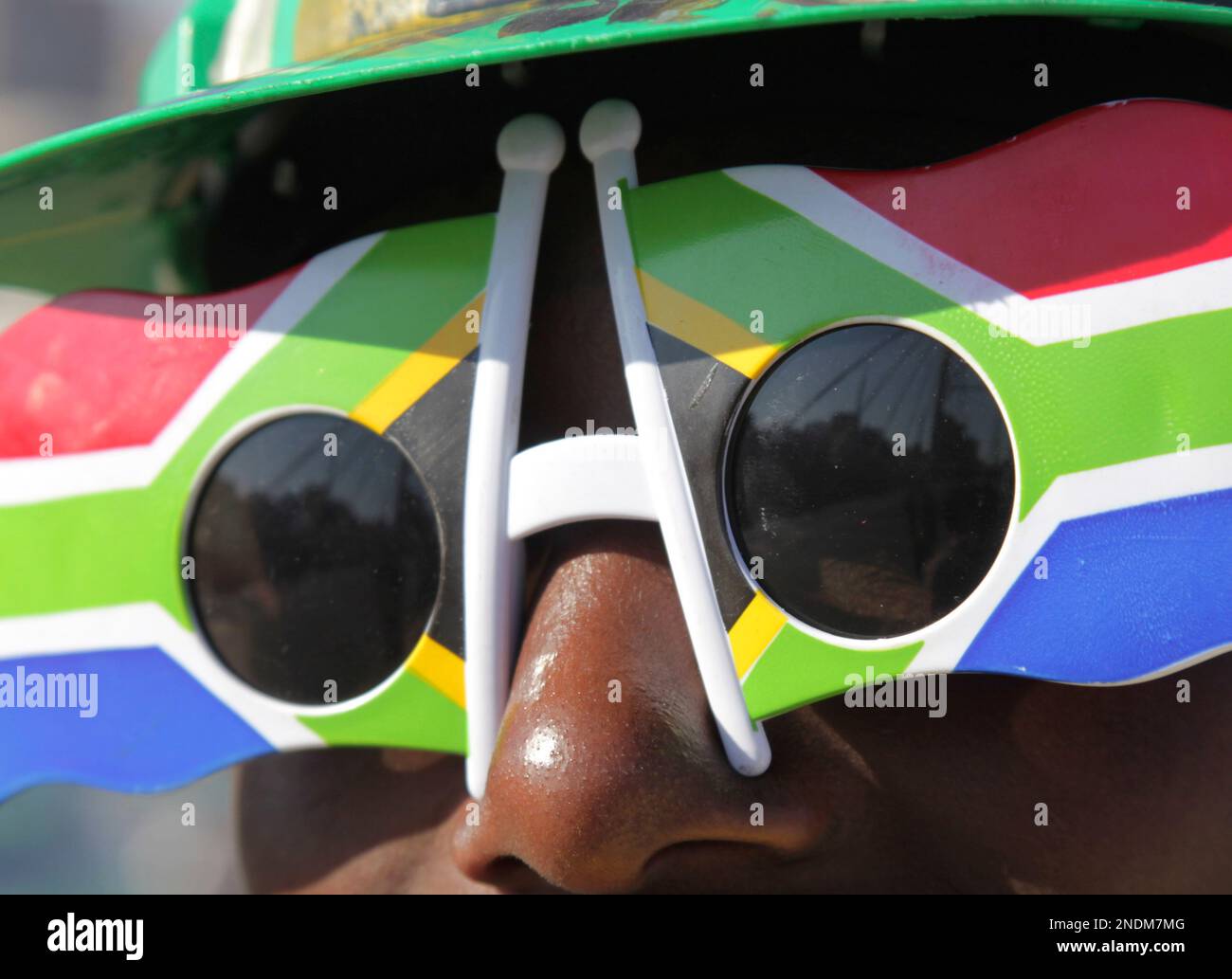 A soccer supporter wears South African flag shades in downtown ...