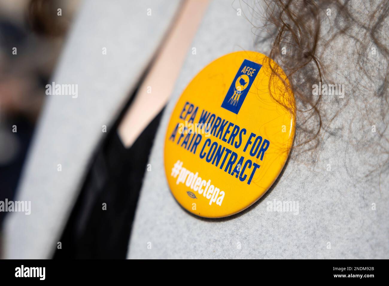 A pin is worn by an AFGE union member during a rally demanding that the ...