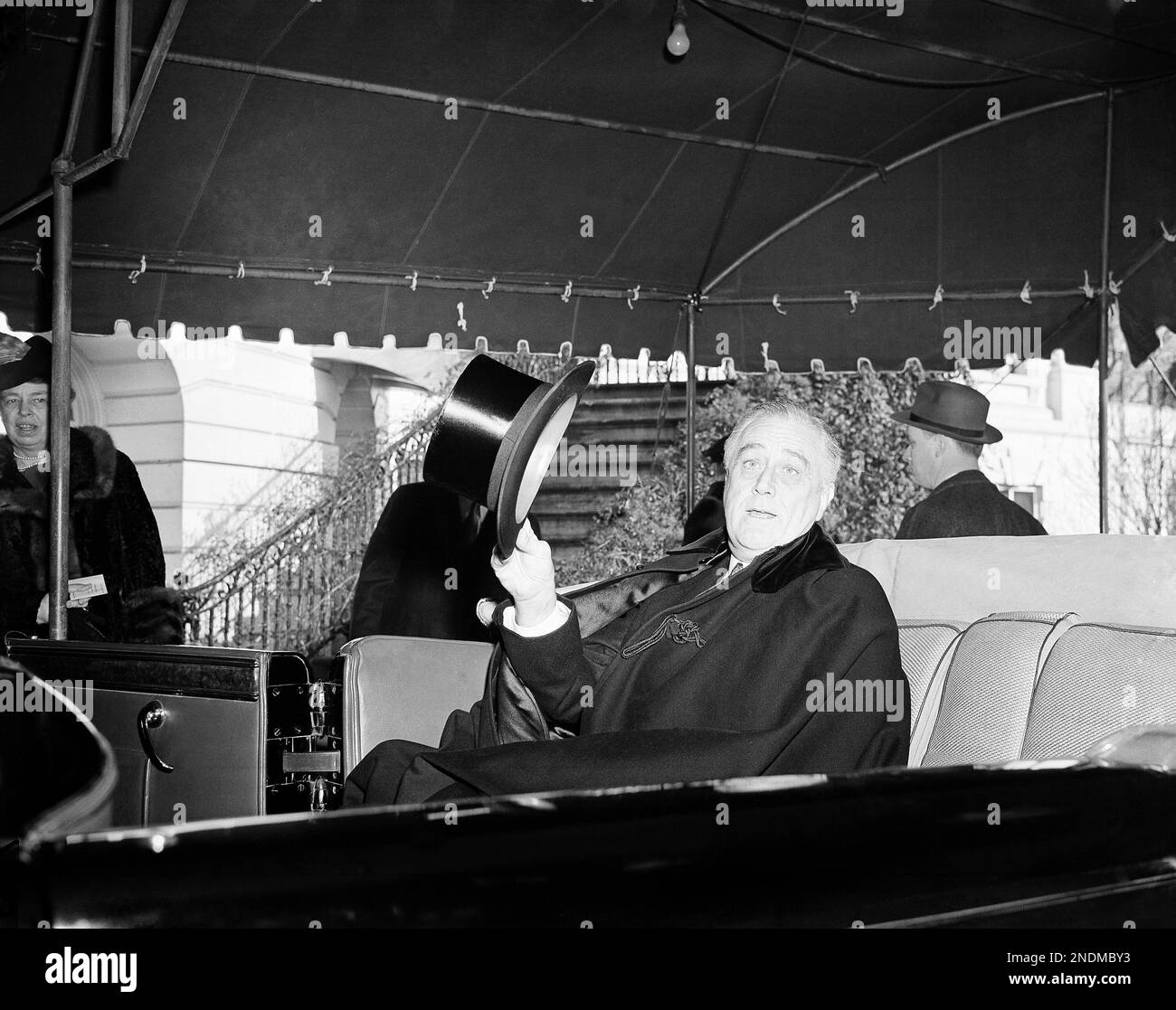 A cape draped over his shoulder, President Franklin D. Roosevelt doffs ...