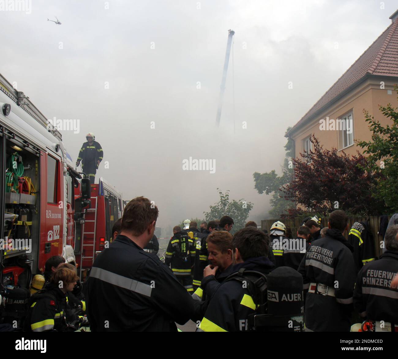 Firefighters inspect stand near of a house after it was destroyed by a ...