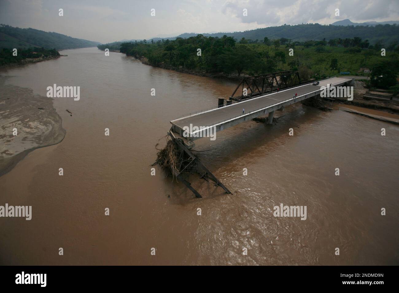 A bridge lays partially collapsed over the Motagua River in Los Amates ...