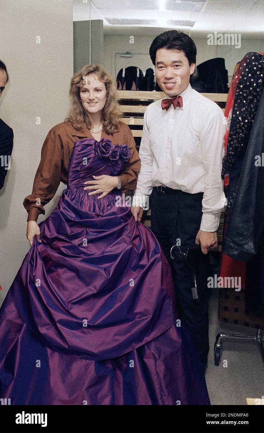 Patty Hearst Shaw holds up a new violet, strapless evening gown by ...