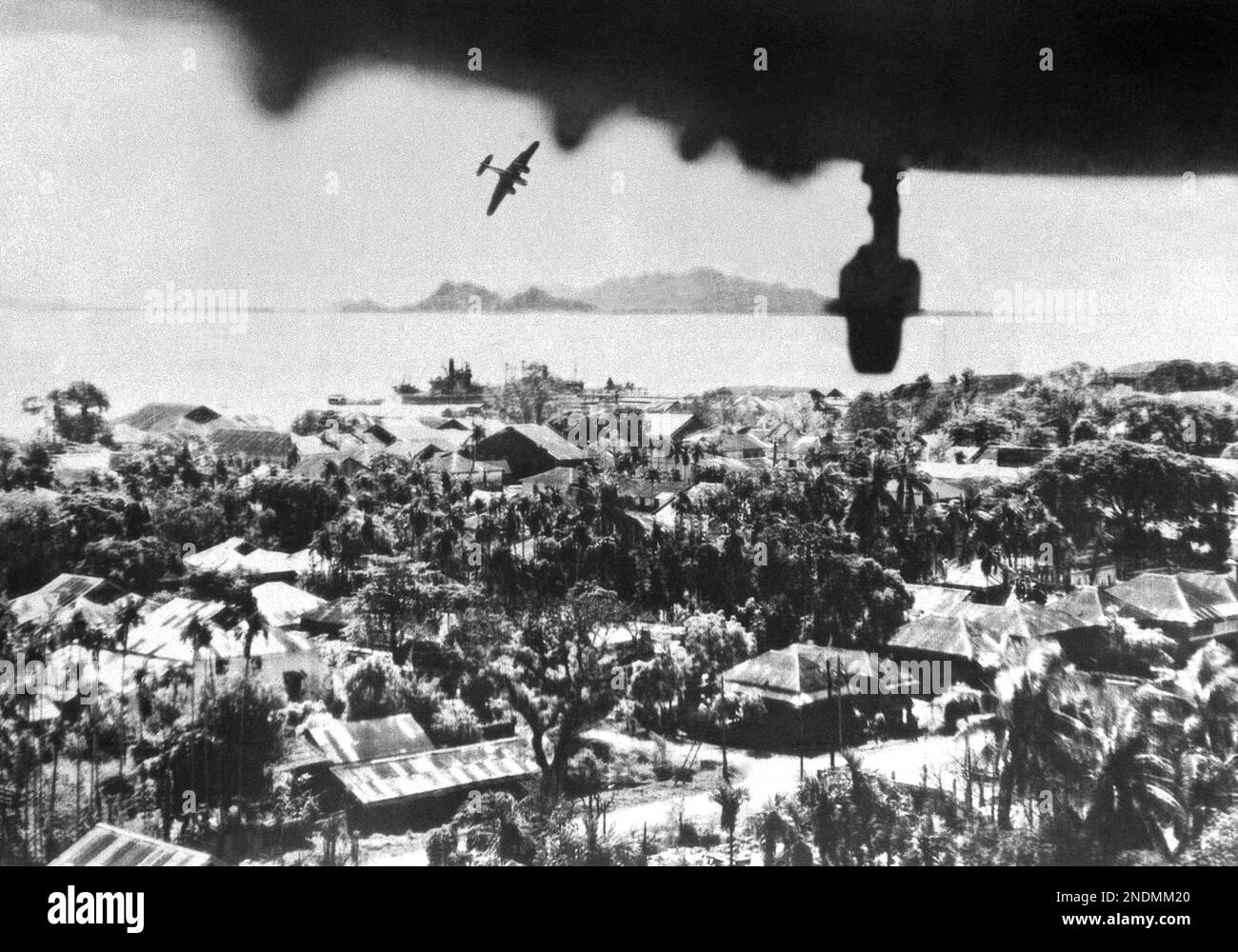 A British Blenheim bomber dives to machine gun shipping in the harbor ...
