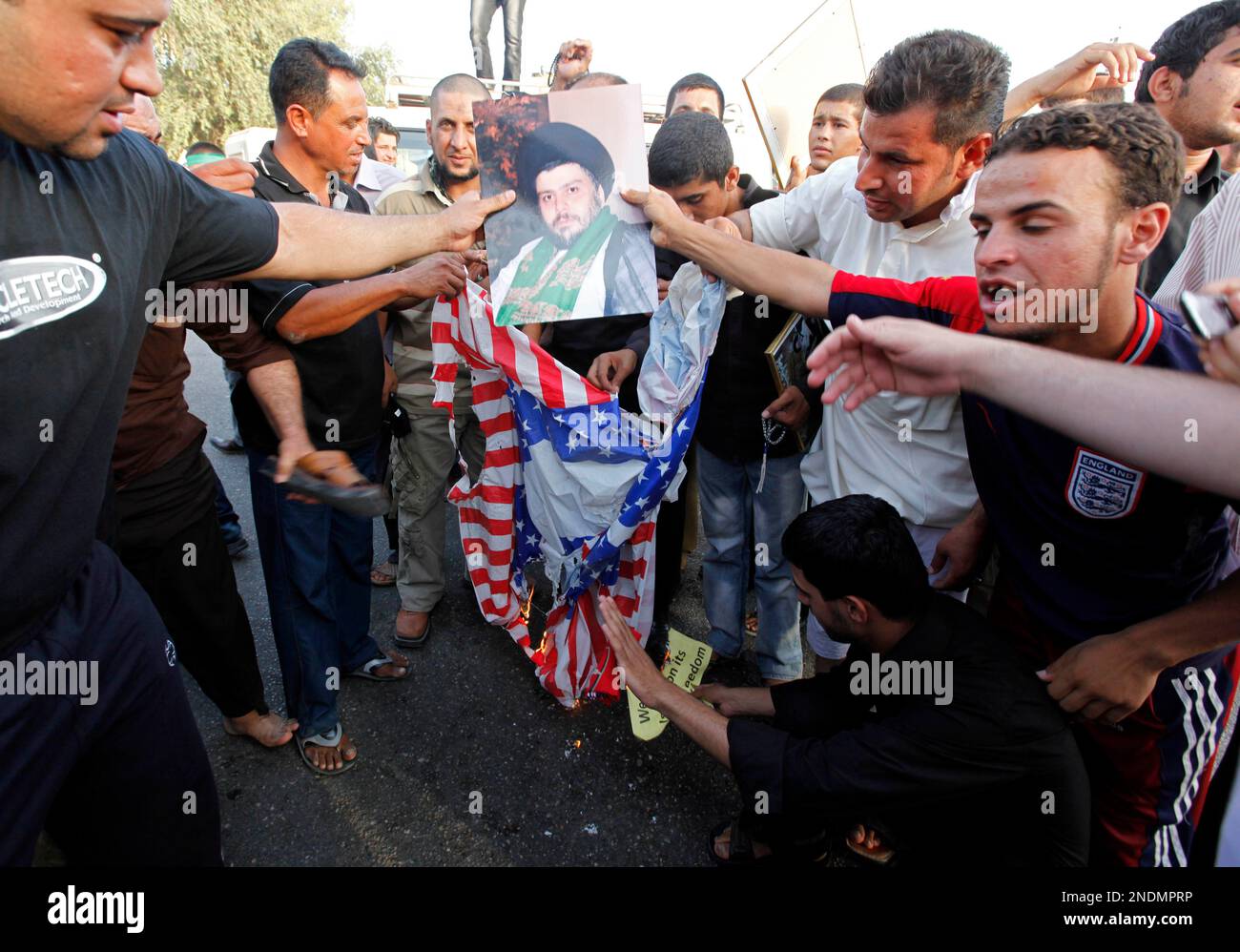 Followers of radical Shiite cleric Muqtada al-Sadr, seen in the poster ...