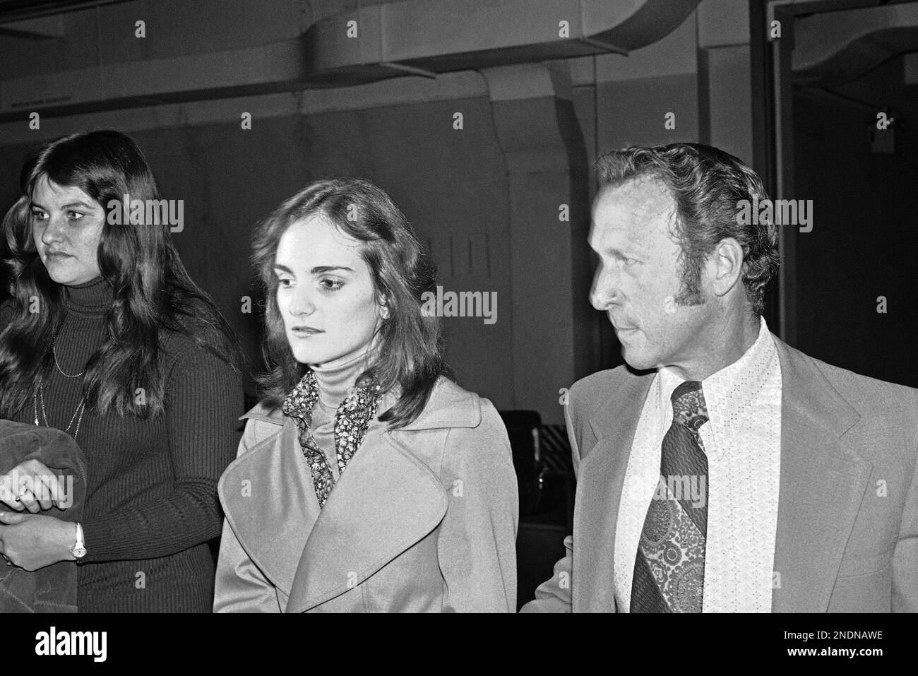 Patty Hearst is escorted by matron Jerri Jewett and Charles E. Burrows ...