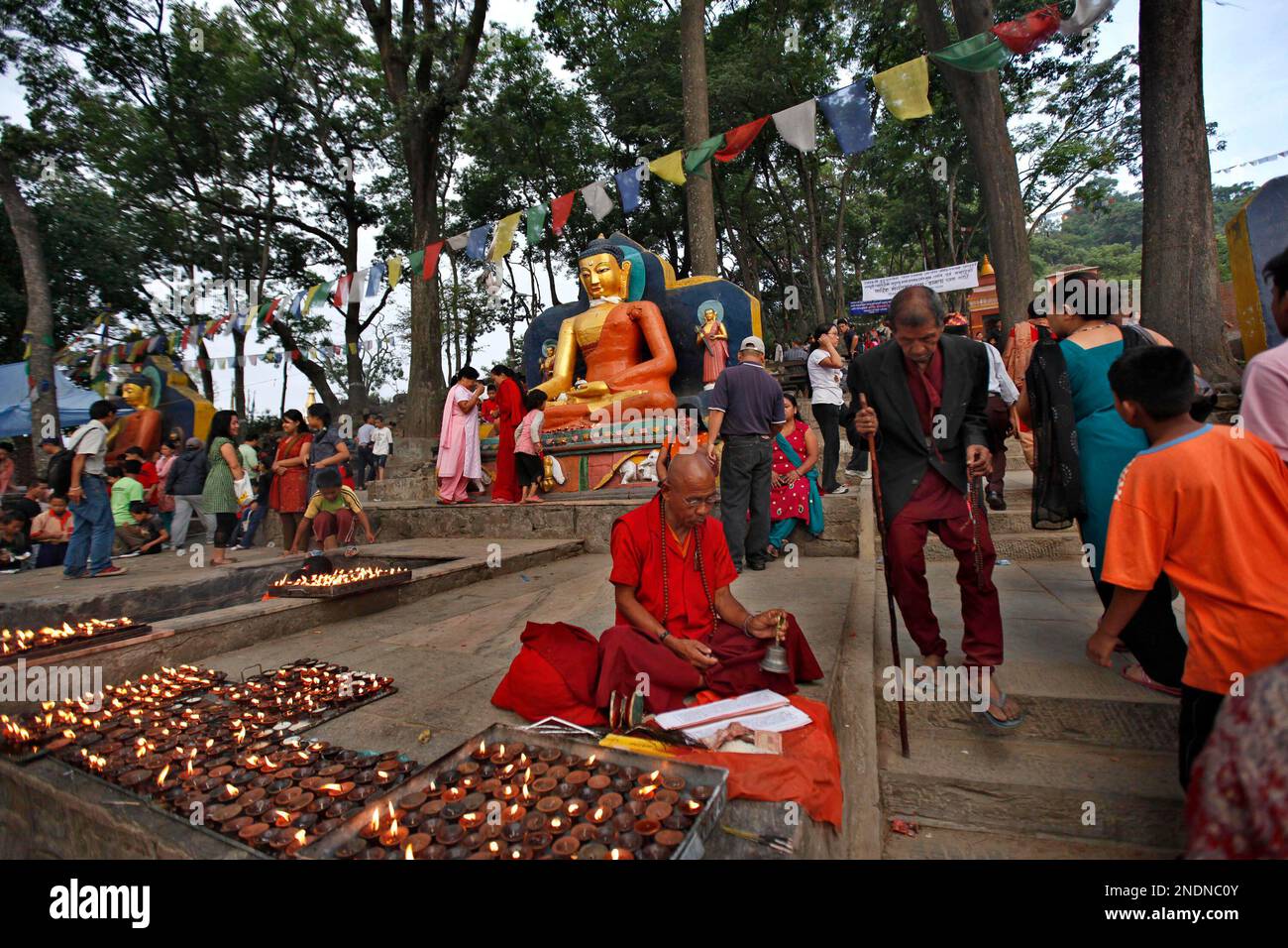 A Buddhist monk prays, as others gather at a Buddhist temple to ...