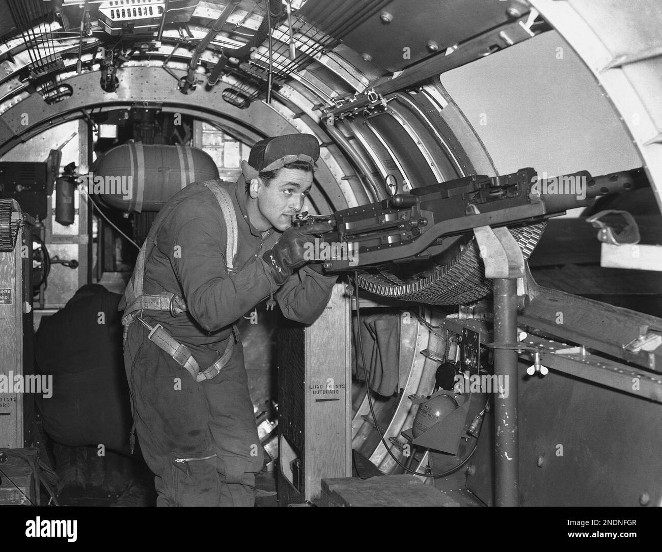 Staff Sergeant Anthony M. Caputo, checks up on the waist gun of his Flying Fortress before ...