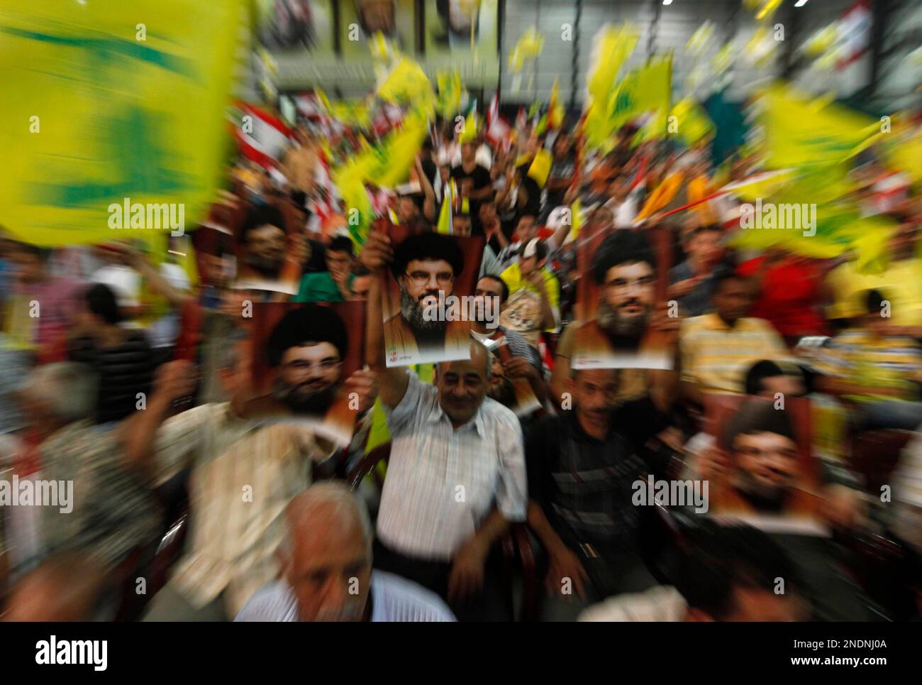 Hezbollah supporters carry pictures of leader Hassan Nasrallah, and ...