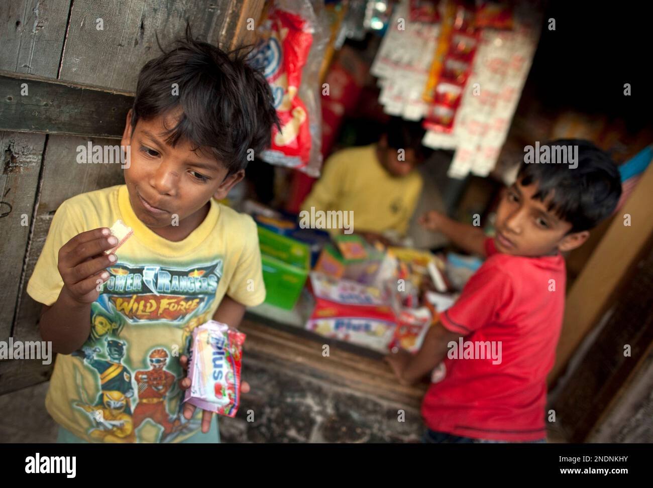 A Pakistani child eats candy at a store in Christian colony in ...