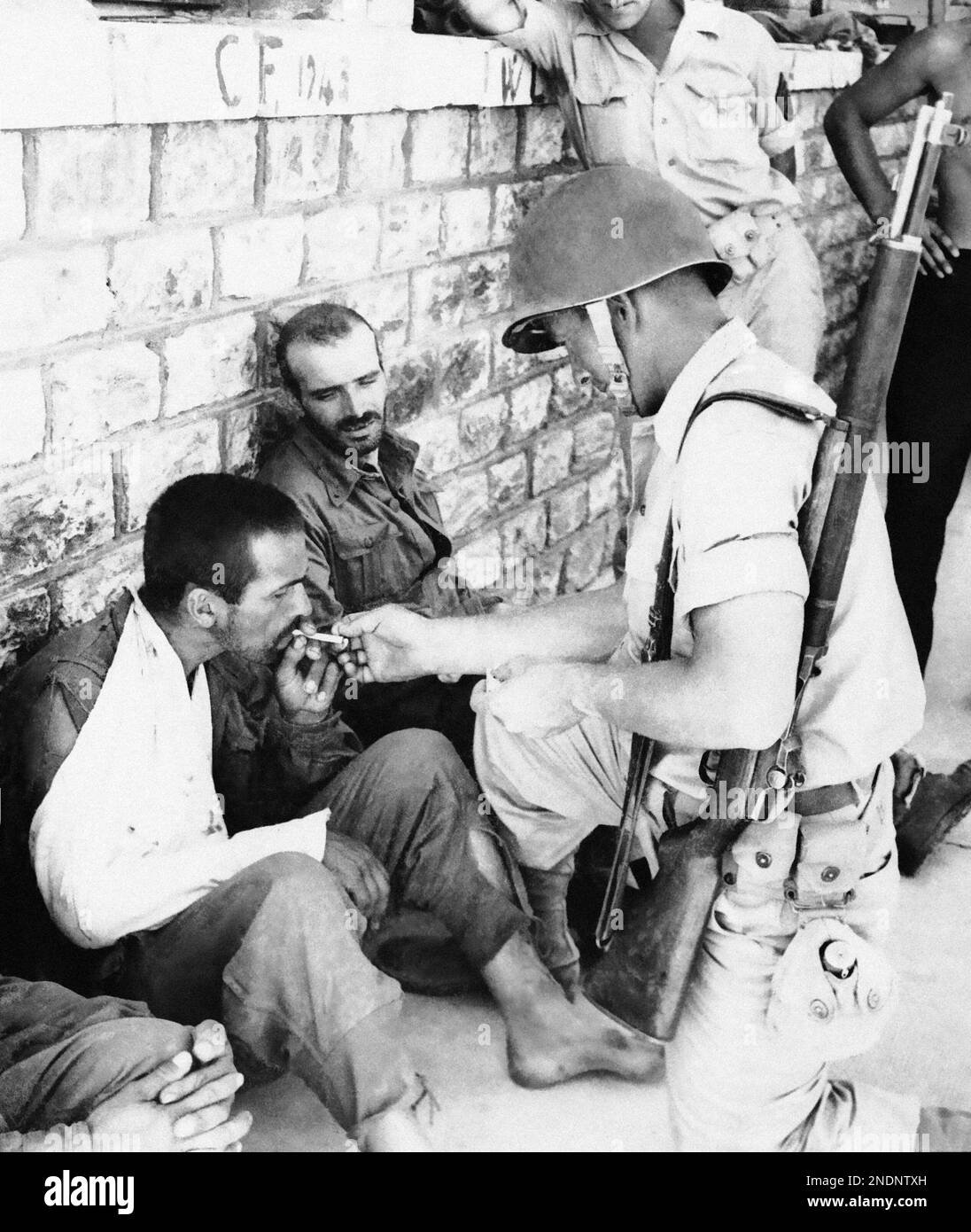 A United States soldier proffers a cigarette and a light to an ill-clad ...