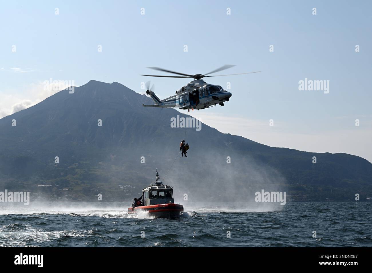 A Japan Coast Guard Mobile Rescue Technician hoists a simulated swimmer ...