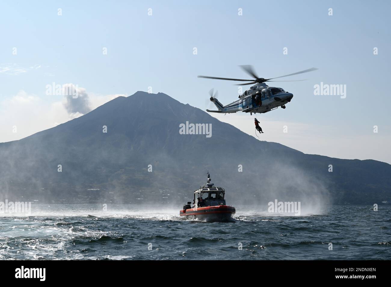 A Japan Coast Guard Mobile Rescue Technician hoists a simulated swimmer ...