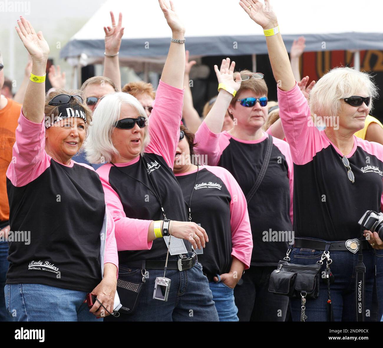 A group of woman wave as motorcycles make their way into the Harley ...
