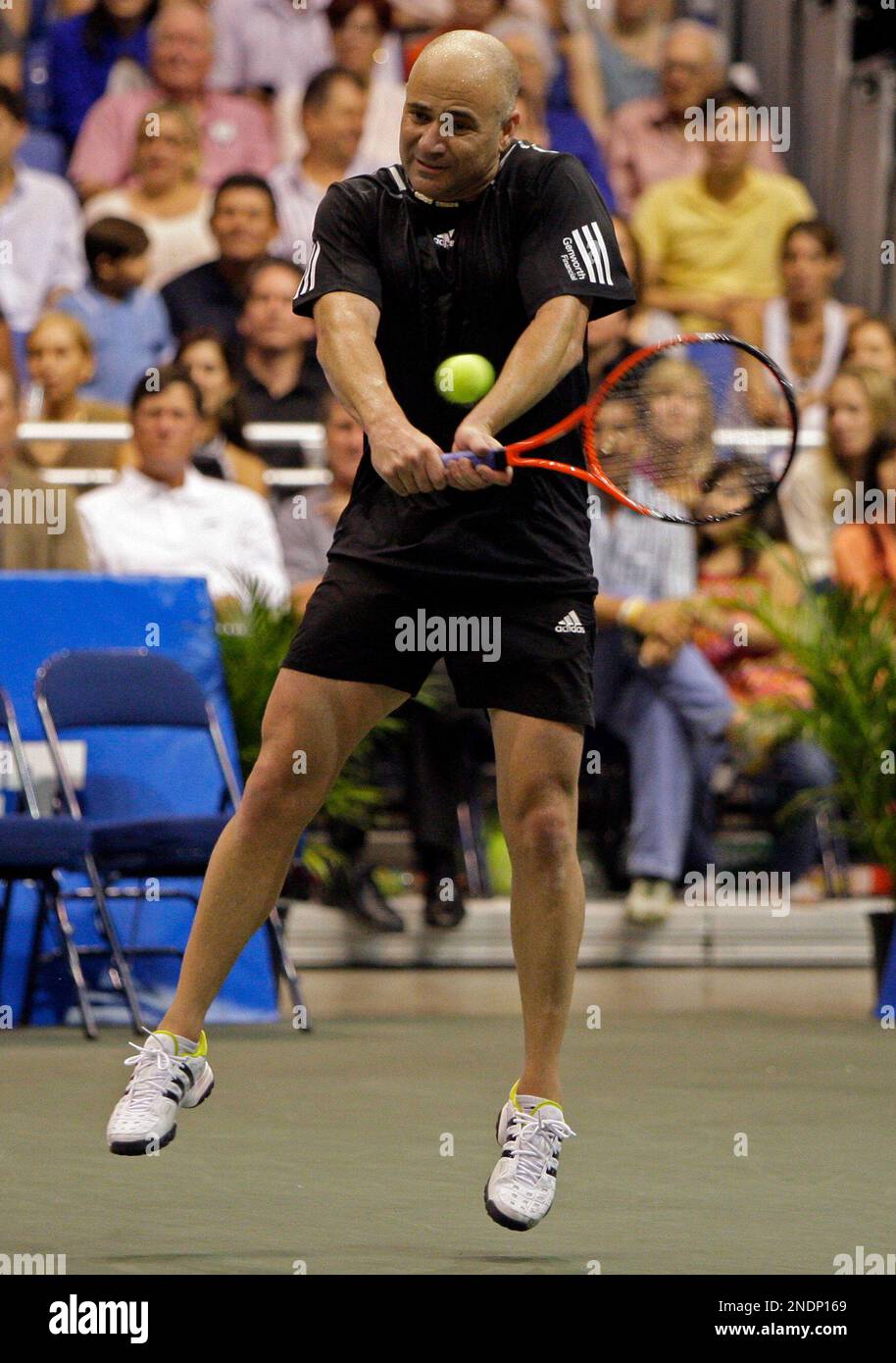 Retired US tennis champion Andre Agassi returns the ball to Pete ...