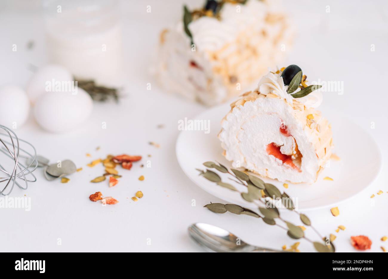 Meringue roll without sugar on white plate cut into pieces in front of ...