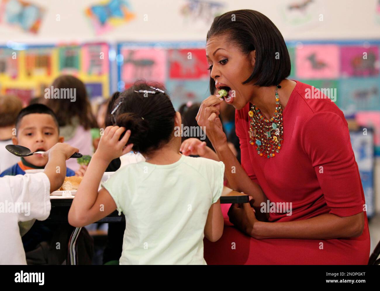 First lady Michelle Obama eats a piece of broccoli as she sits down to ...