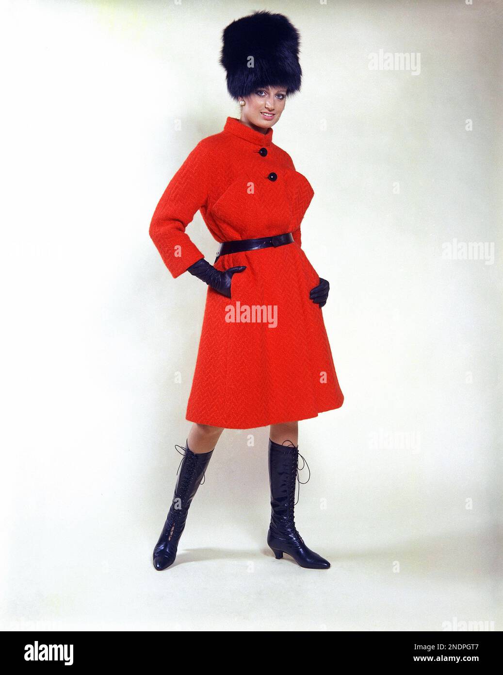 “Igor” is a coat of red wool worn with a busby shaped hat of black fur ...