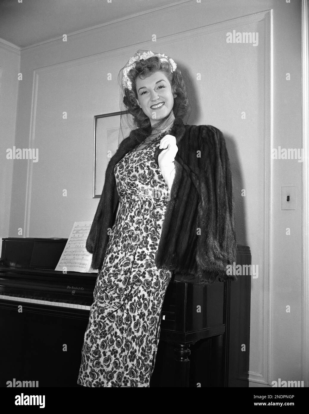 Opera singer Rise Stevens wears a hip-length mink jacket and a frock ...