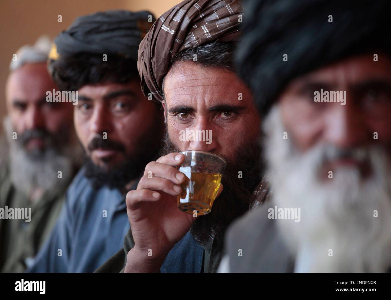 An Afghan man drinks tea as he listens to conversation between U.S ...