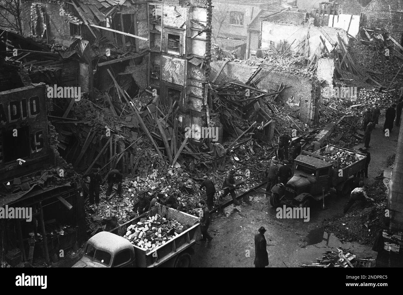 Demolition squads at work clearing away the debrison Poplar High Street ...