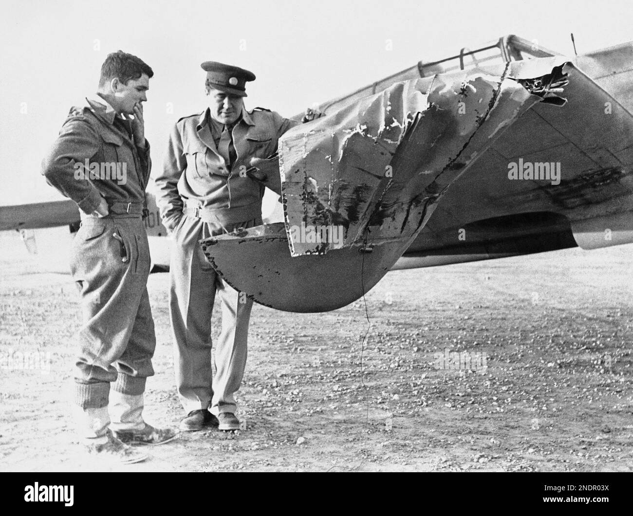 A South African fighter pilot (left) examines the damaged wing of his ...