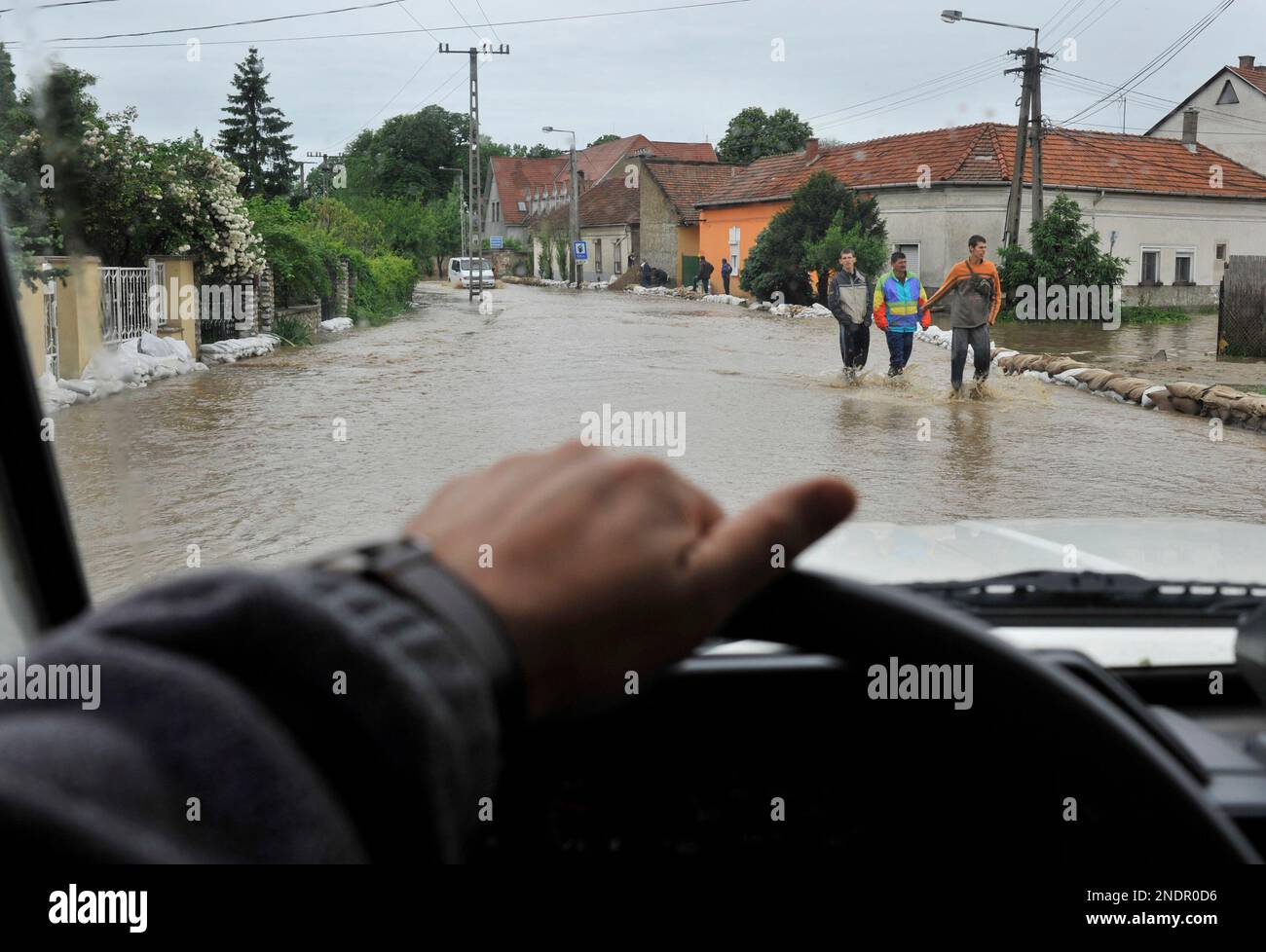 People walk through a flooded street in Szikszo, northeastern Hungary ...