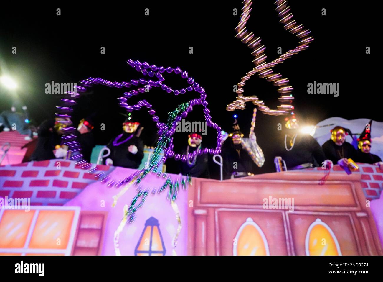 Float riders throw beads as the Krewe of Druids Mardi Gras parade rolls ...