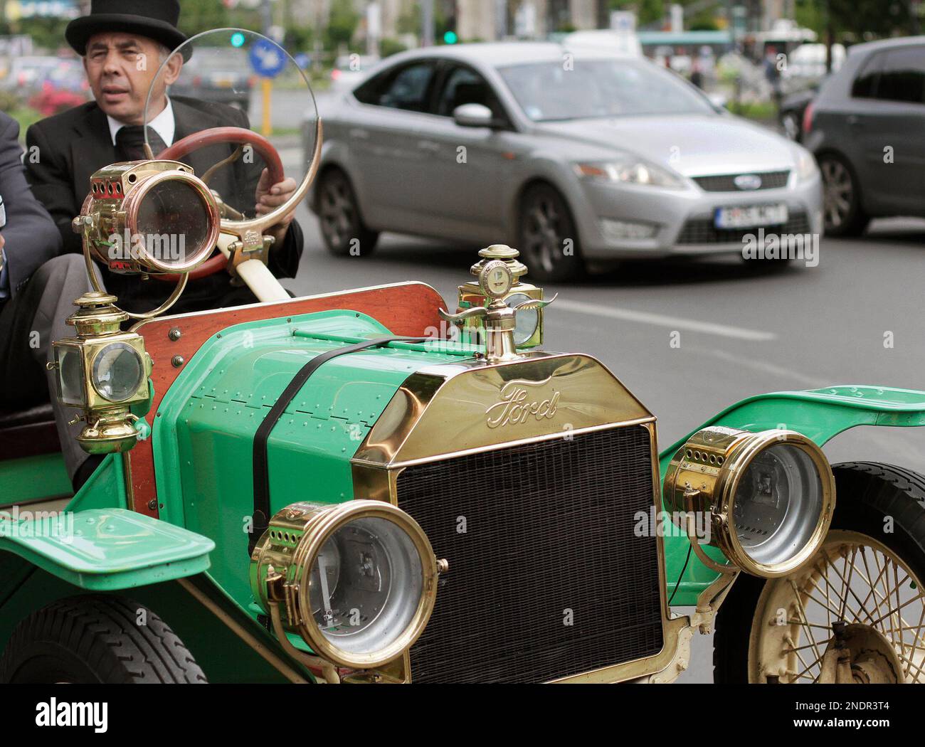 A man drives a 1912 Ford Speedster, next to a modern verchile during a ...