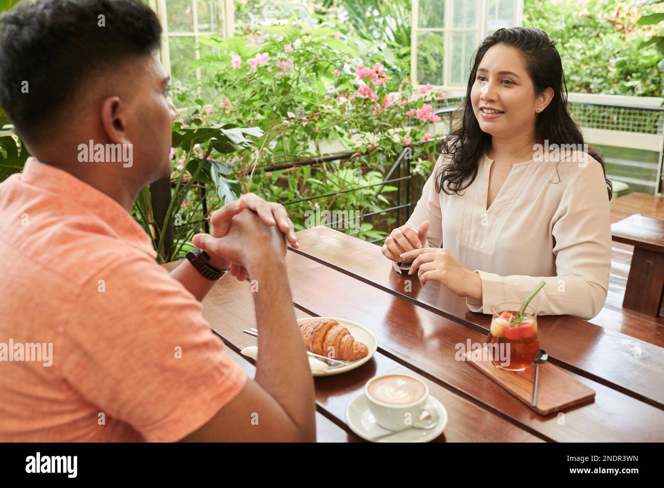 Excited young woman listening to friends talking about whats new in his ...