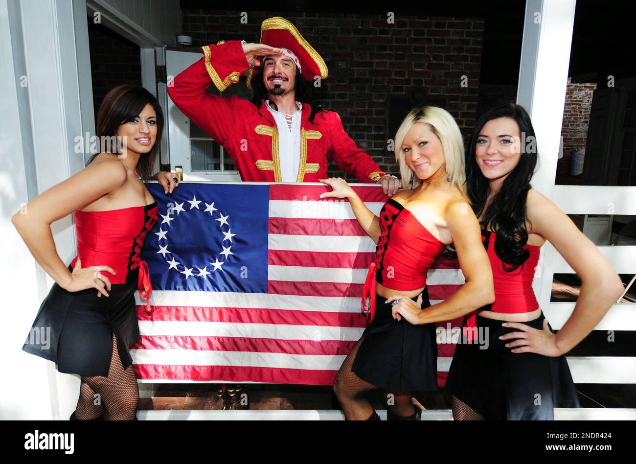 Captain Morgan and the Morganettes pose in front of a flag at Betsy ...