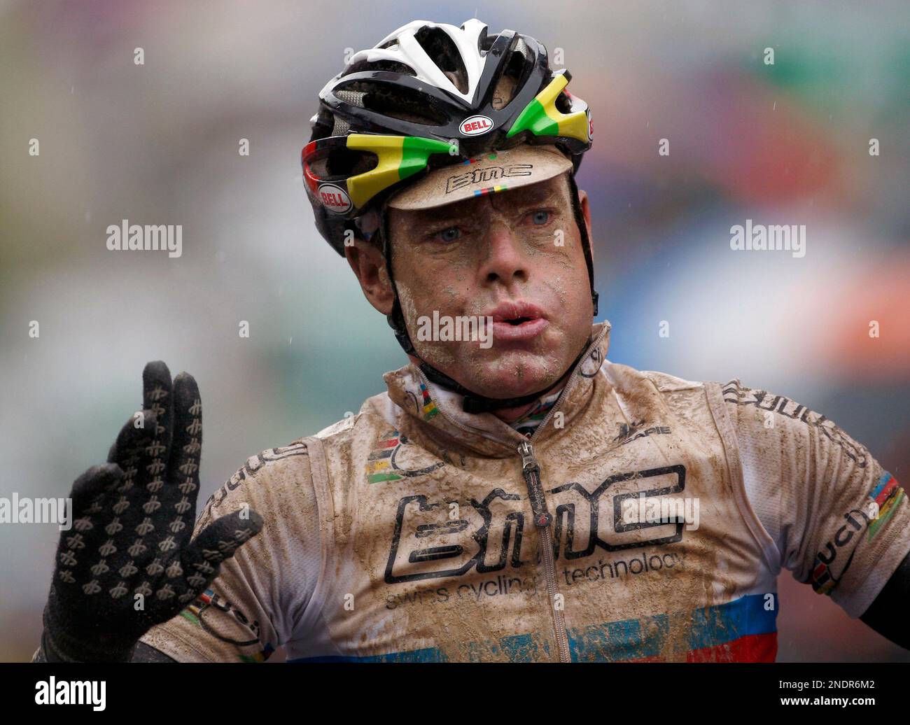Australia's Cadel Evans, his face covered in mud, crosses the finish ...
