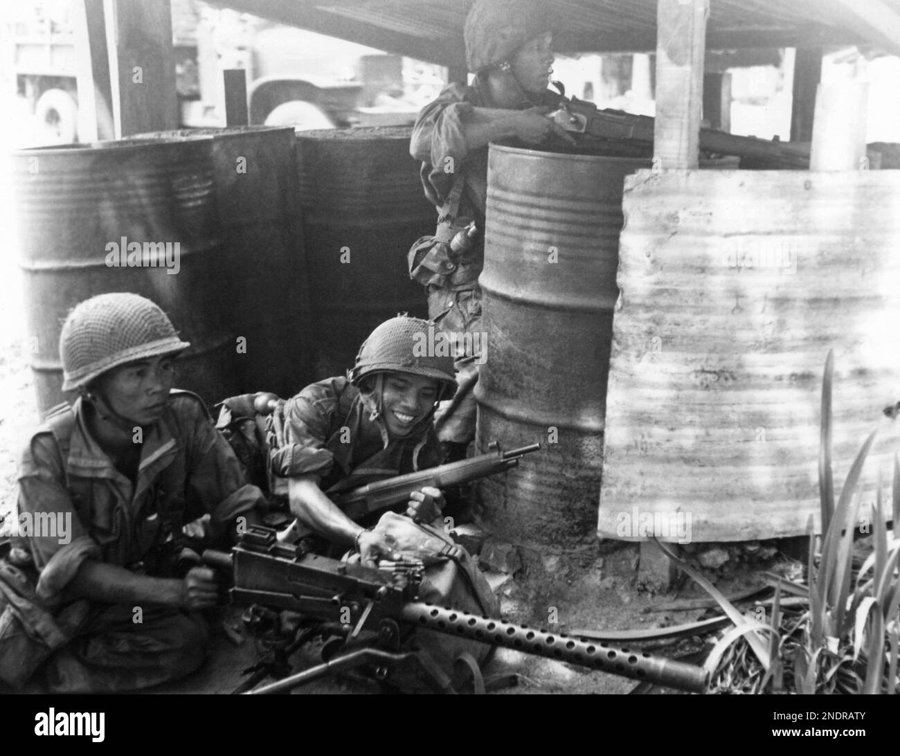 Two National Army soldiers crouch behind machine gun as fighting rages ...
