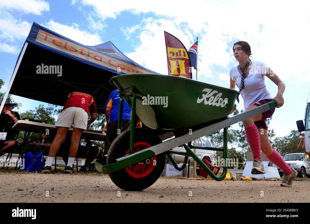A competitor sprints from the start line pushing a wheelbarrow at the ...