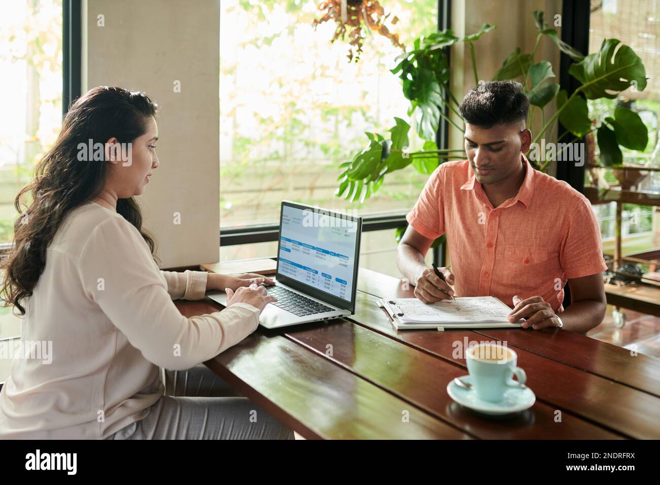 Businesswoman checking data on laptop when her colleague analyzing ...