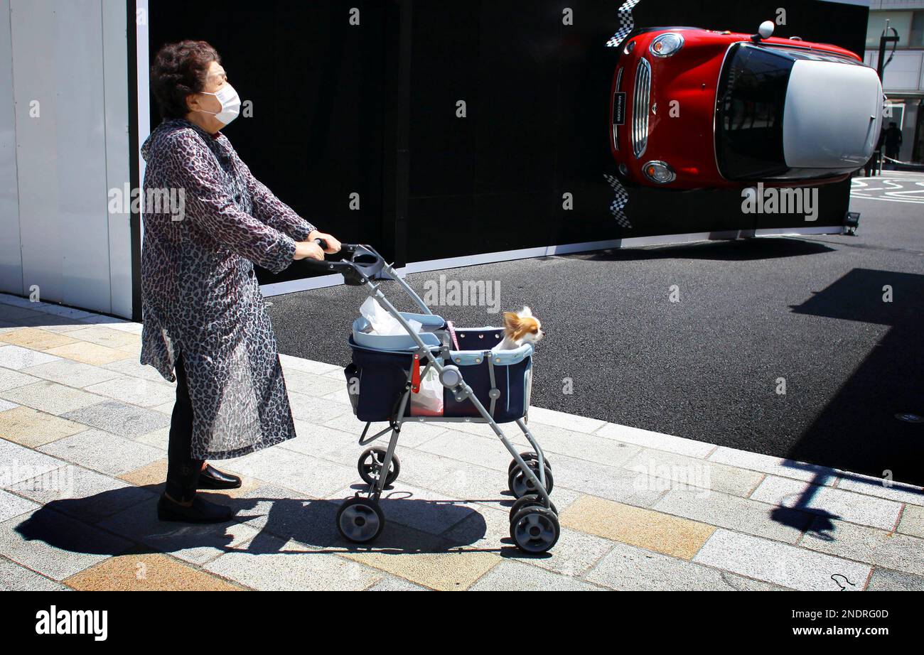 A woman walks by a life size model of a MINI Cooper on display outside ...