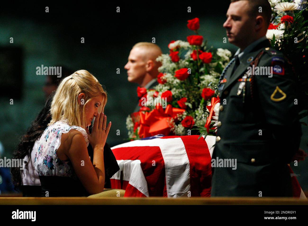 A young woman pauses at the American Flag draped casket of U.S. Army ...