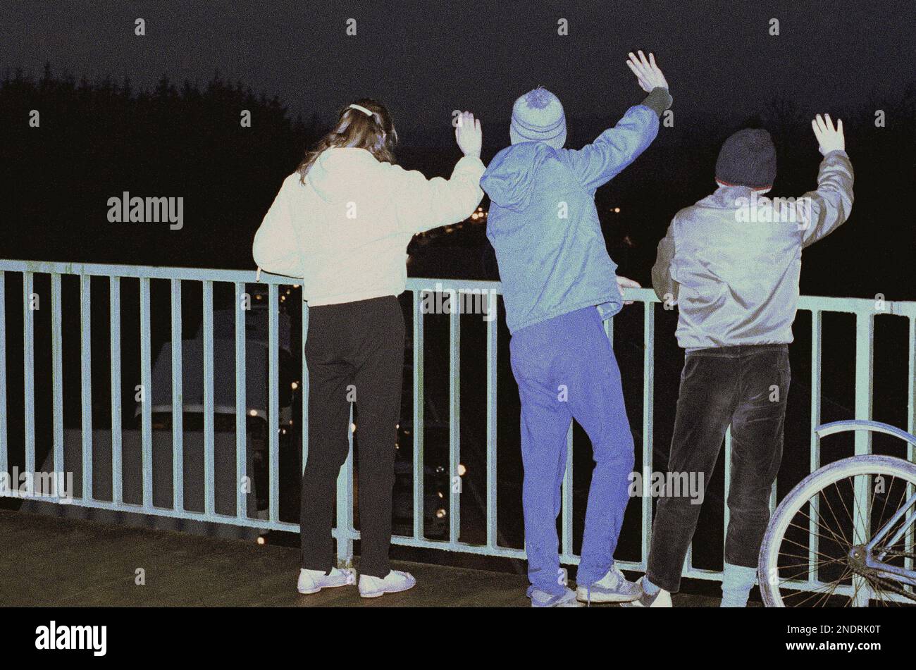 Bicyclists wave from an overpass over a highway from East Berlin to ...